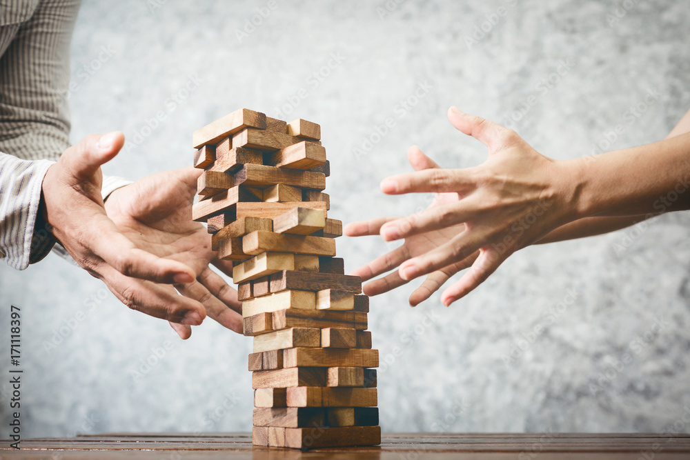 Asian man and woman playing wood jenga game. Stock Photo | Adobe Stock