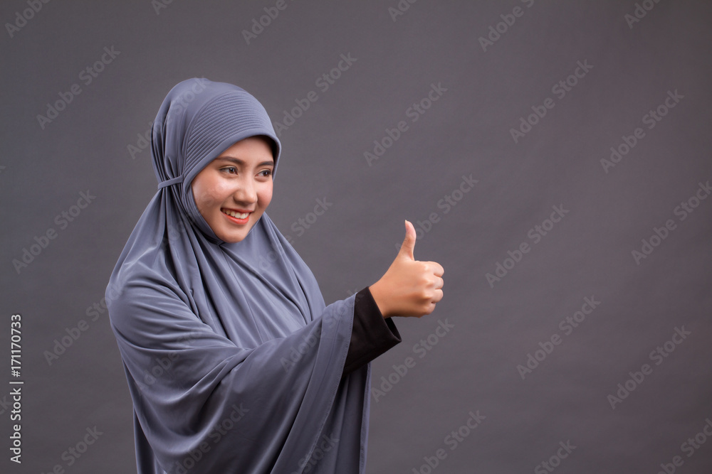 muslim woman pointing thumb up side way, asian islamic woman model ...