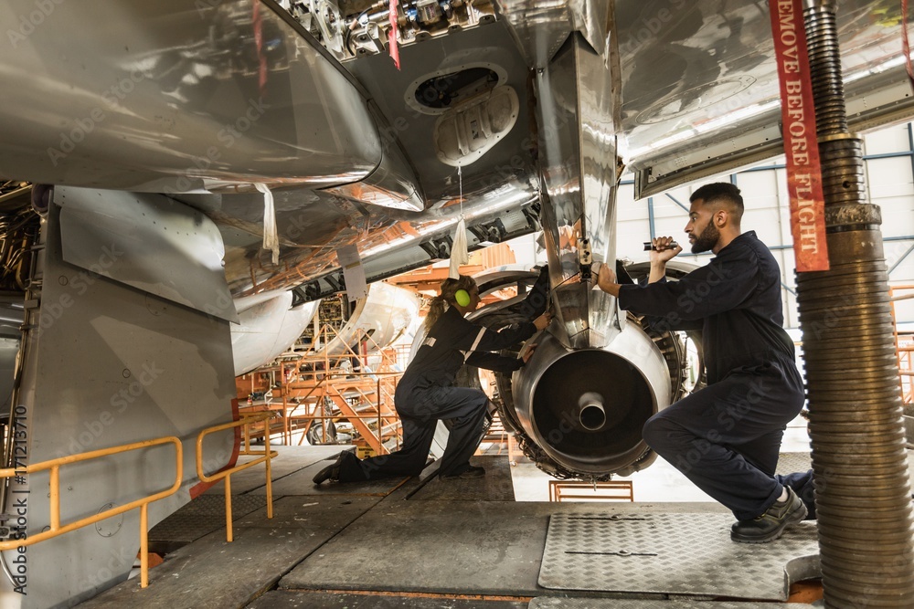 Aircraft maintenance engineers examining turbine engine of Stock Photo ...