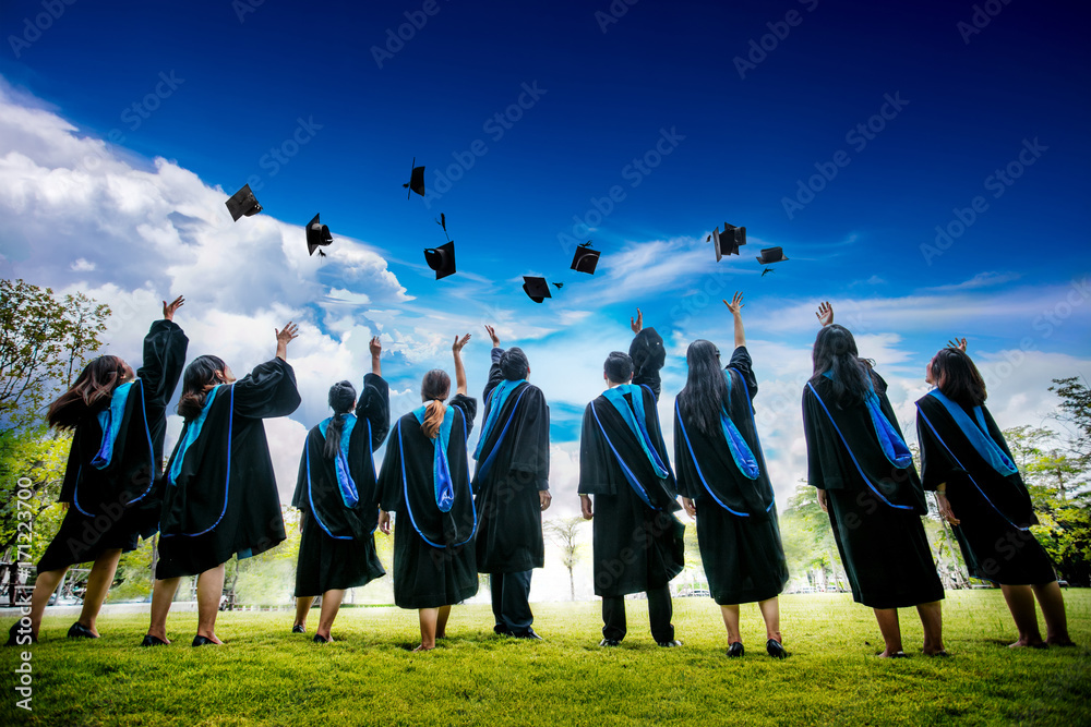 Group of graduates with congratulations throwing graduation hats in the ...
