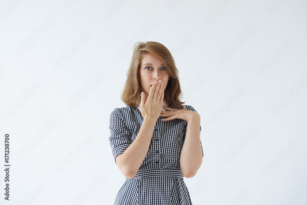 Body language. Surprised amazed young female in dress covering mouth ...