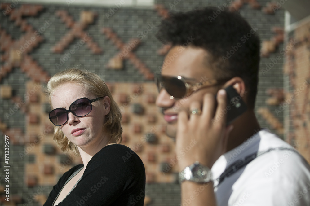 Junge Frau genervt von Freund der telefoniert Stock-Foto | Adobe Stock