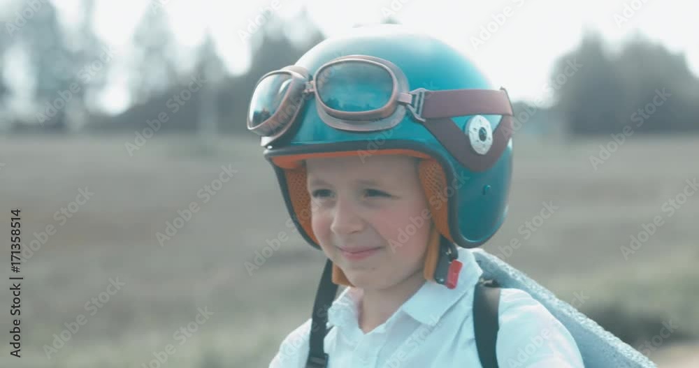 CU Little boy wearing helmet taking off vintage googles, pretending to ...