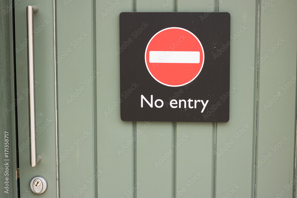 Closed green door with an international obvious sign "No entry ...