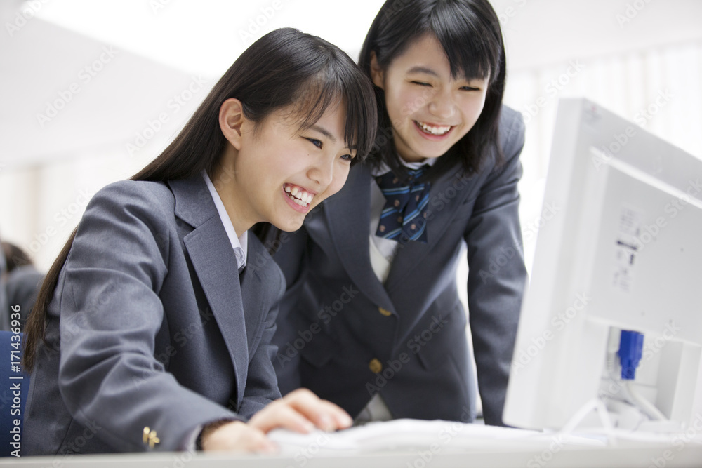 School girls in school uniform sharing computer in the classroom Stock ...