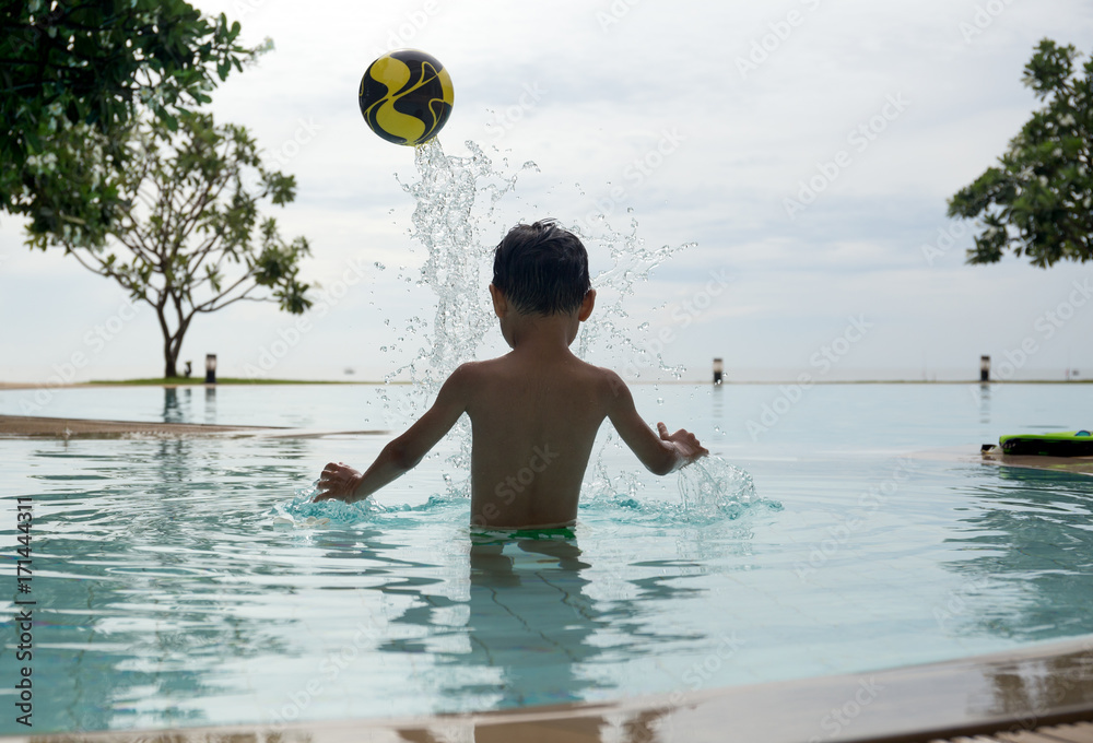 Little boy playing a ball in swimming pool Stock Photo | Adobe Stock
