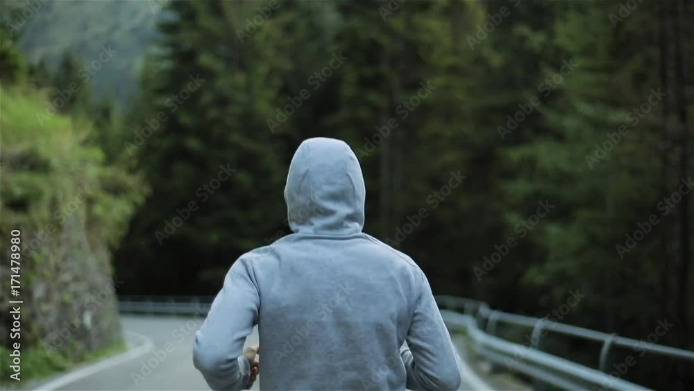 Man jogging on mountain road no face back close up slow motion. Alone ...