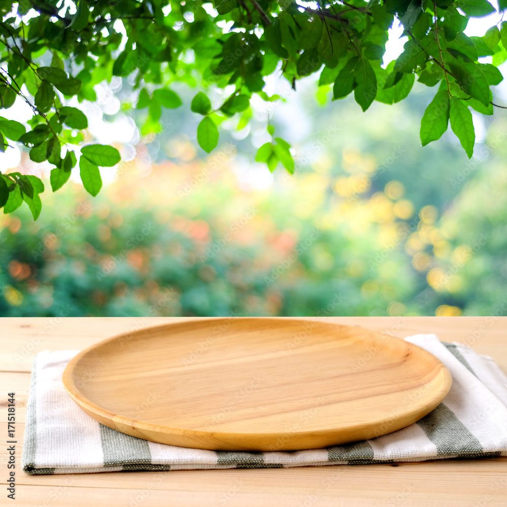 Empty wooden tray on table over blur green park background, food ...