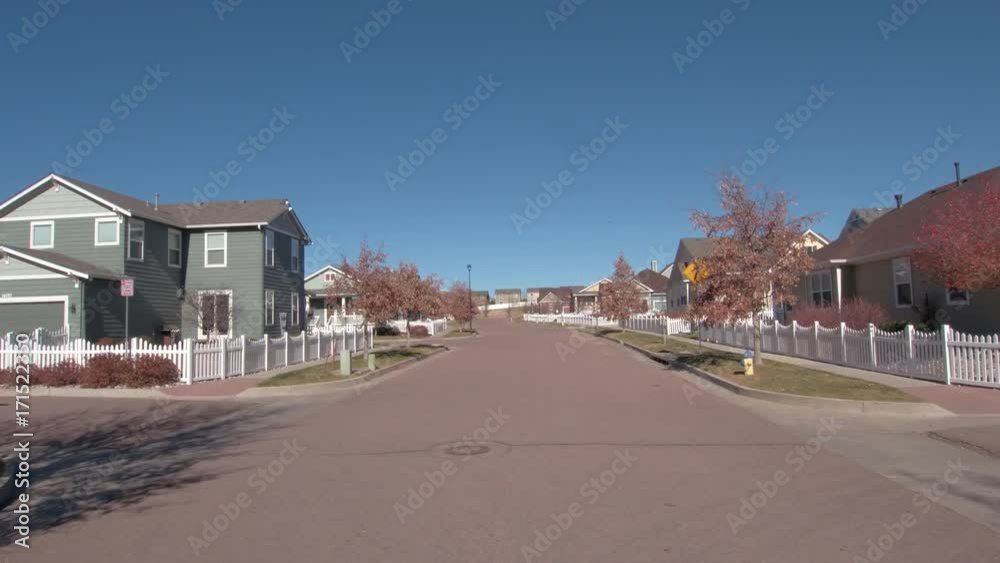 FPV, CLOSE UP: Driving past the idyllic suburban houses behind the ...