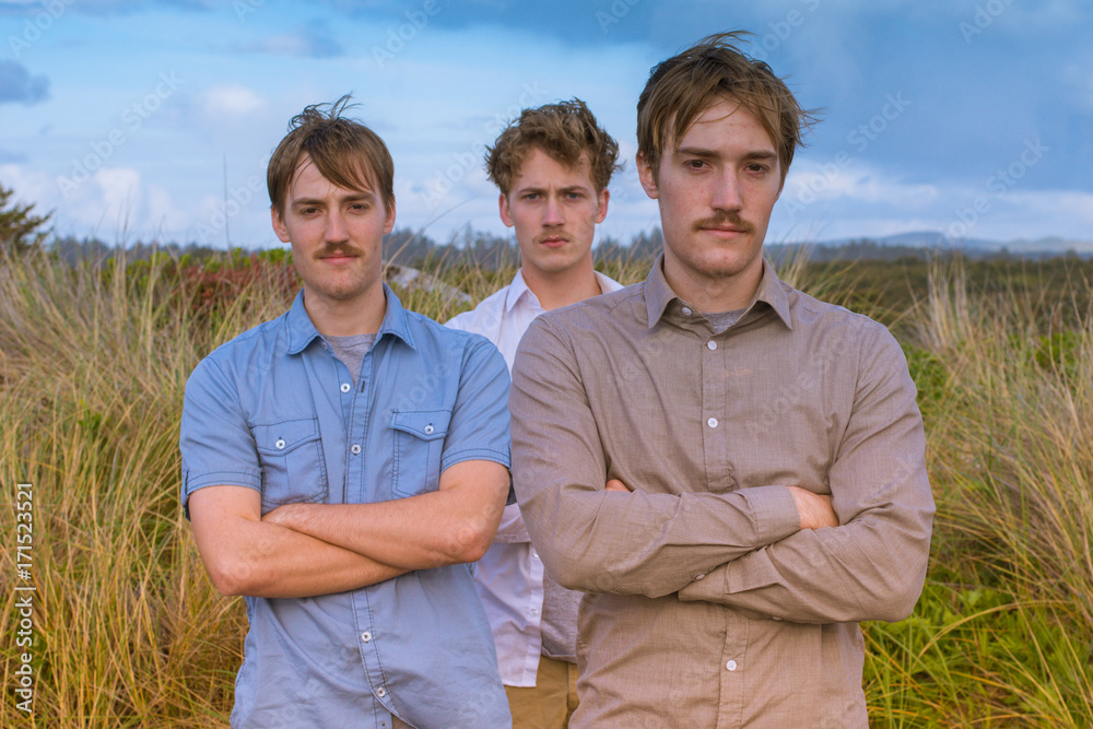 Three young handsome men posing with their arms crossed Stock Photo ...