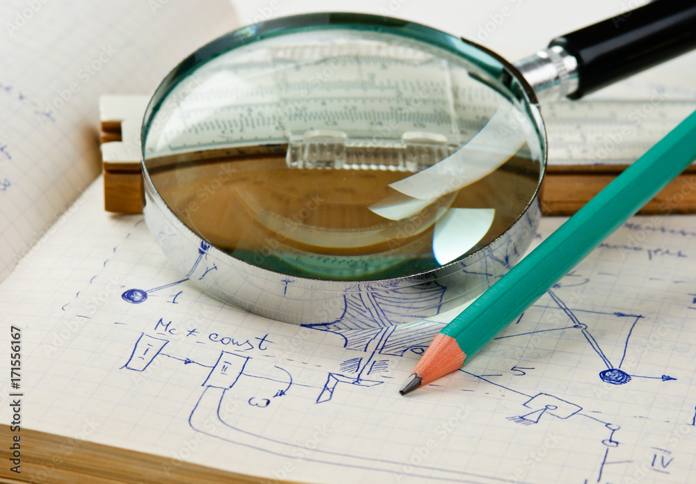 magnifying glass and a slide rule on the old page with the calculations ...