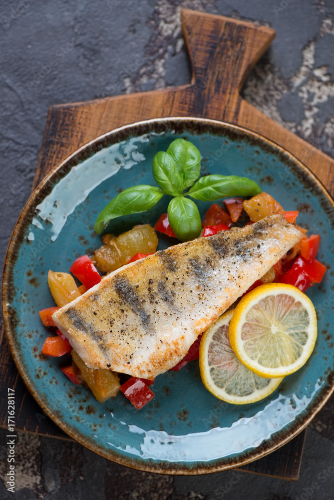 Top view of roasted sudak fish with sauteed vegetables, vertical shot ...