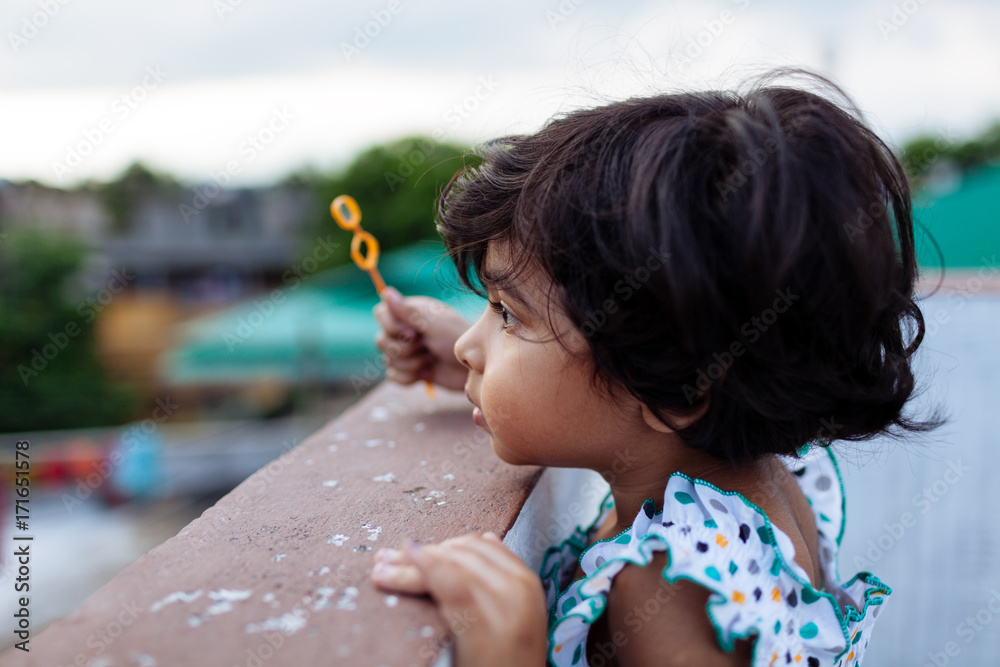 Little girl peeking over a wall Stock Photo | Adobe Stock