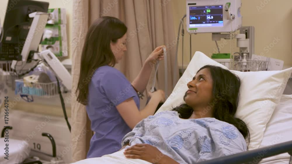 Nurse takes a patient's vitals, including blood pressure, pulse and ...