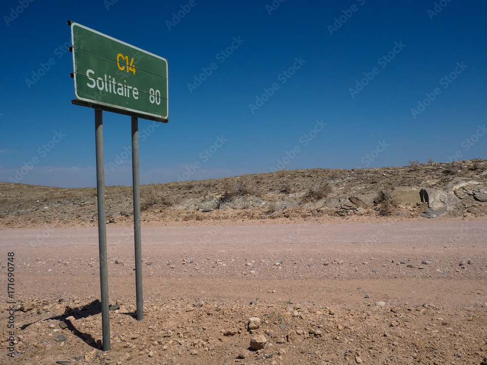 Green color directional road sign pole along unpaved dirt road C14 to ...
