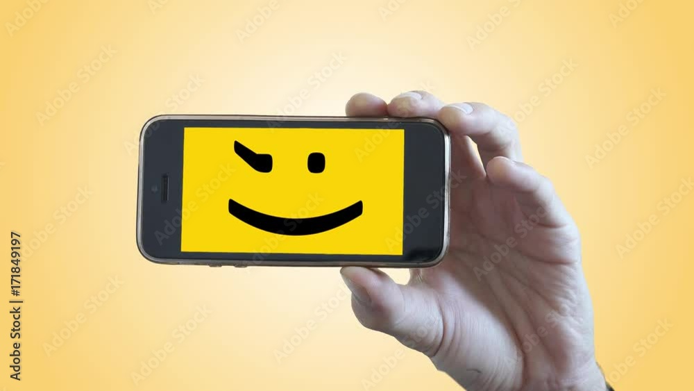 Hand Holding Happy Smartphone Winking Face. Male hand holding a ...