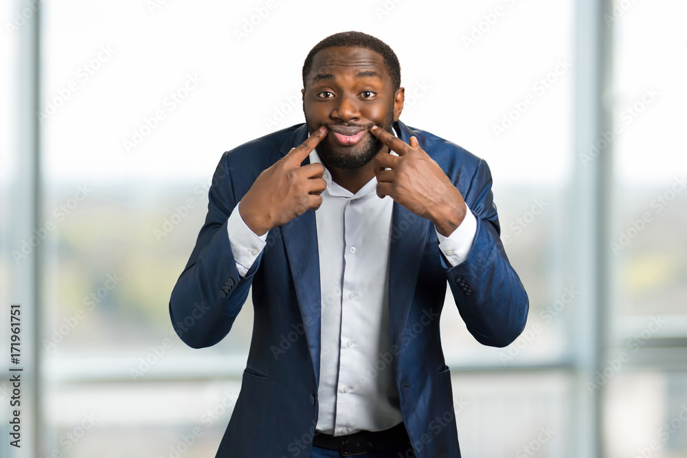 Black businessman with artificial smile. Businessman making a face at ...