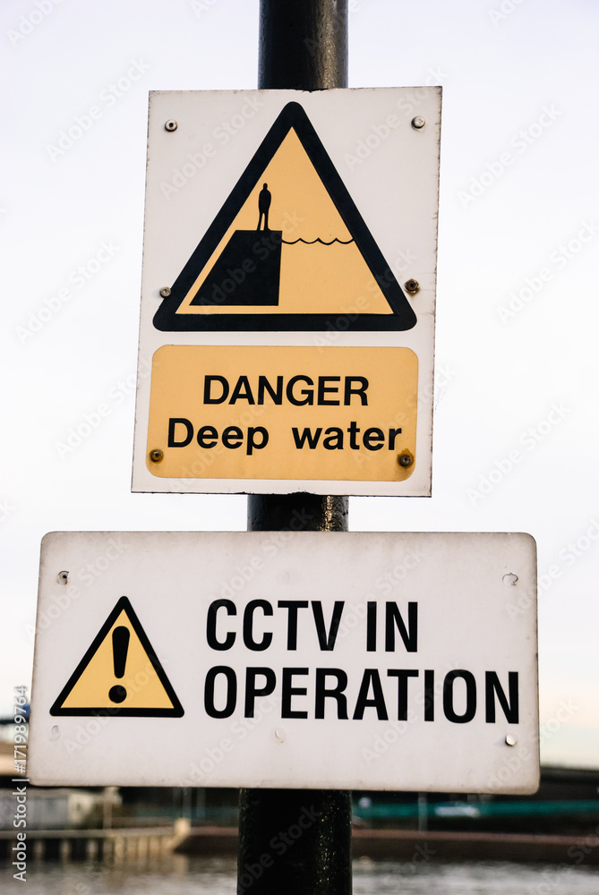 Signs at a harbour warning about deep water, and that CCTV is in ...