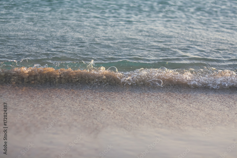 Delicate shoreline background, sea wave foam on pink sand under sunset ...