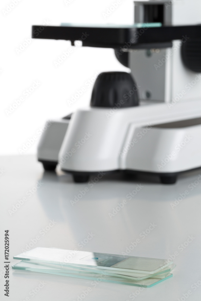 Stack of specimen holders in front of microscope Stock Photo | Adobe Stock