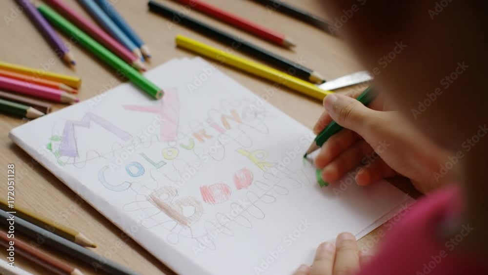 Handheld shot of young girl creating her own colouring book Stock Video ...