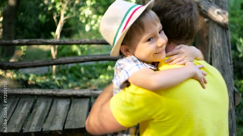 Affectionate father dad coming home and hug his son who is waited him ...