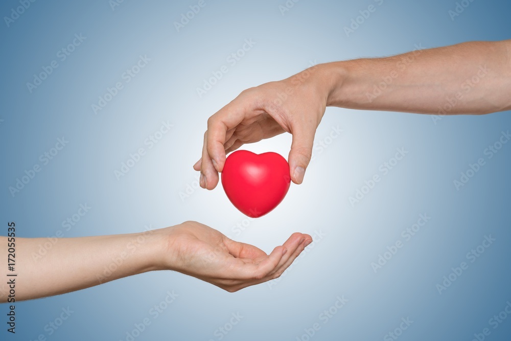 Heart transplant and organ donation concept. Hand is giving red heart ...