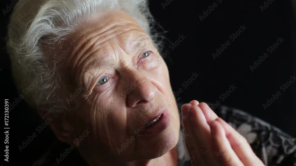 old woman praying to God. Face close-up on a black background Stock ビデオ ...