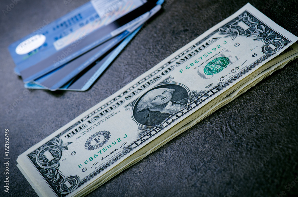One dollar banknotes on a black table with credit cards. Cash money ...