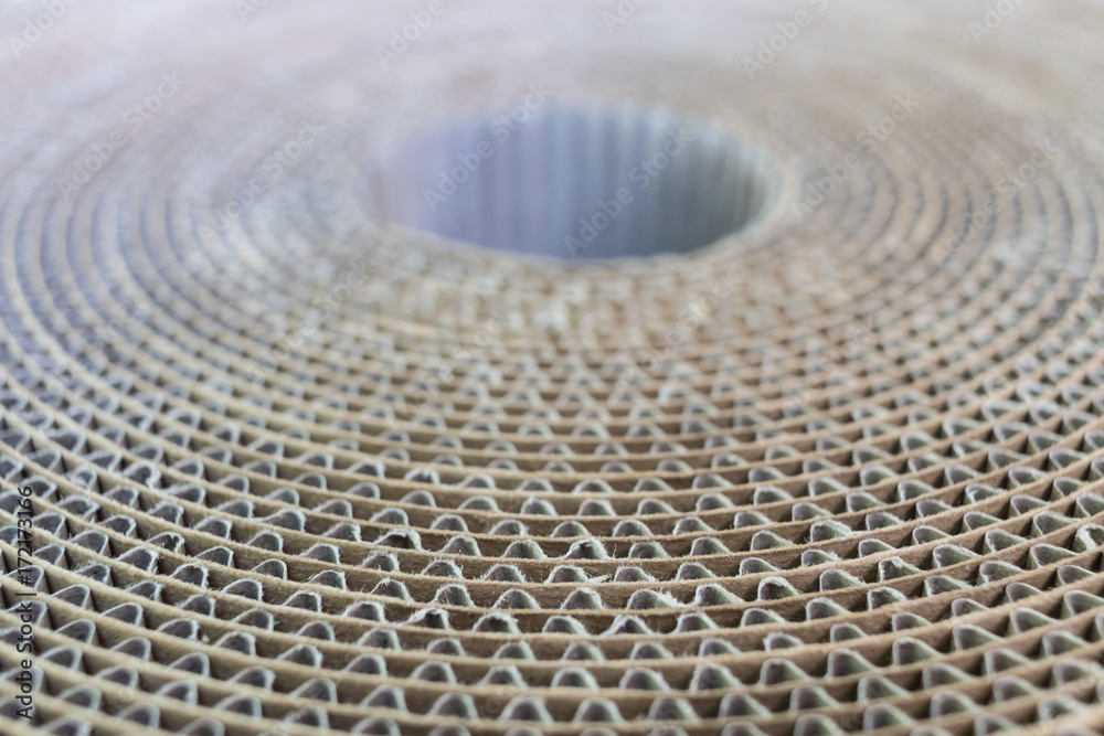 Top-down view rolled up cardboard at an angle with blurry background ...