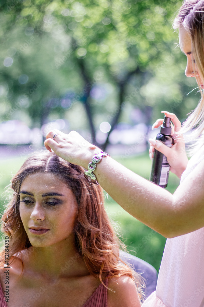 Stylist spraying hairs of young girl with hair spray. Stock-Foto ...