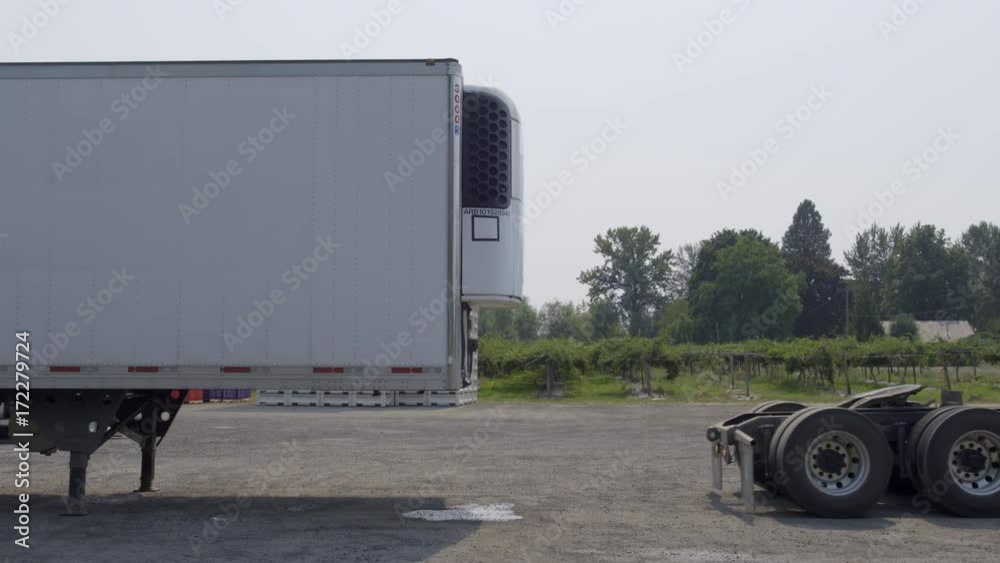 White truck cab reverses and makes connection to white trailer on ...