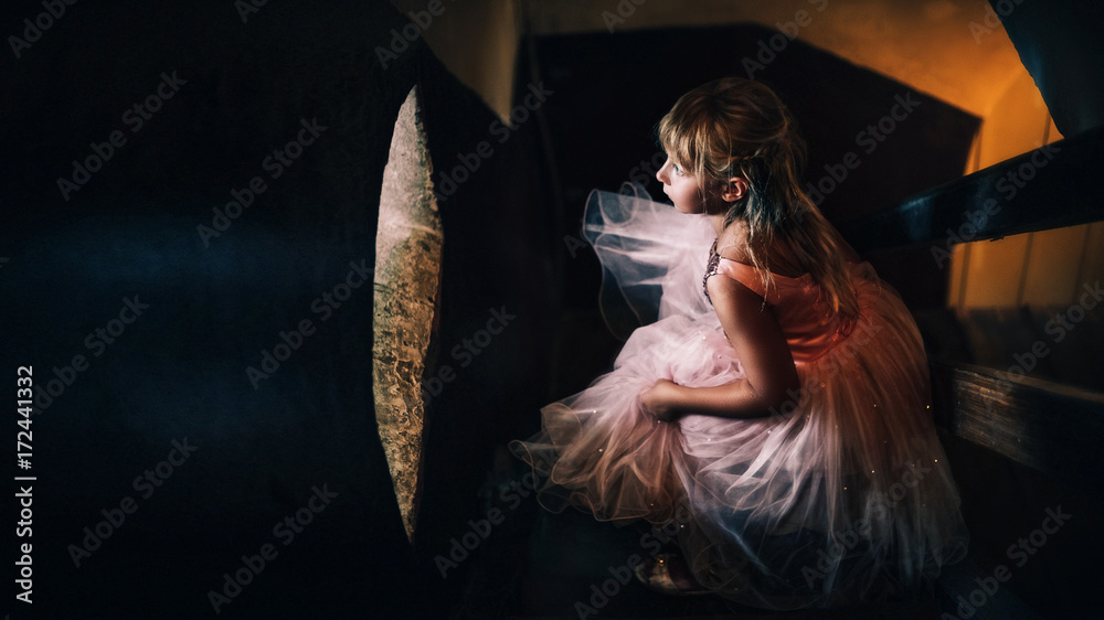 little princess in an old castle.a little girl with blond hair in a ...