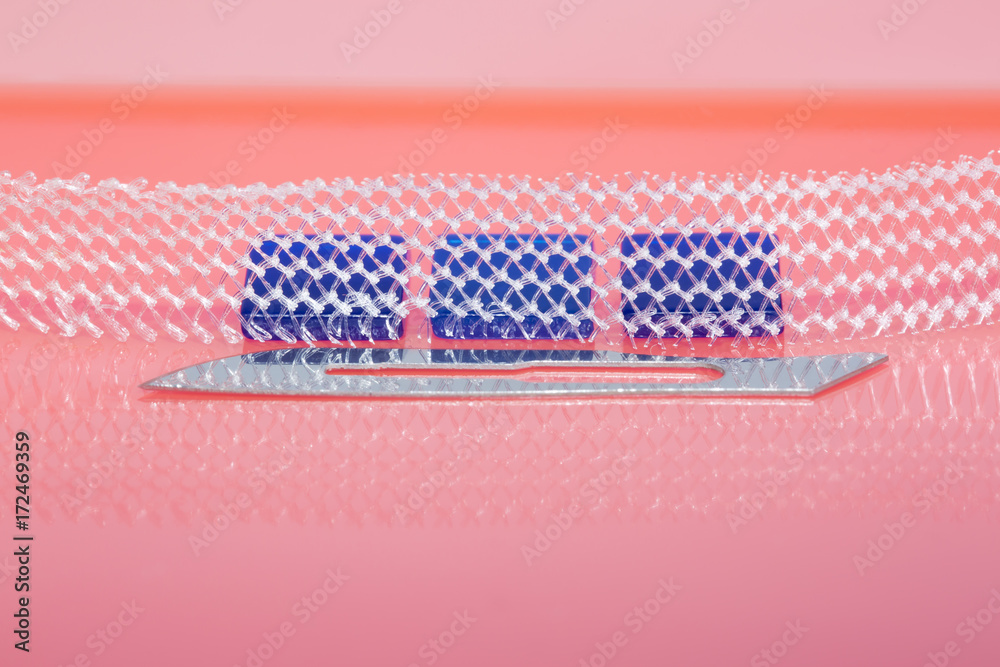 TVT surgery concept. Surgical knife in front of tension-free vaginal ...