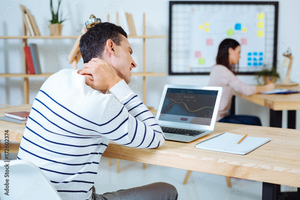 Young office worker sitting at his place Stock Photo | Adobe Stock