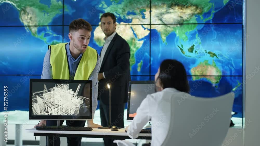 Wideo Stock: Engineering team in discussion looking at large world map ... Wideo Stock: Engineering team in discussion looking at large world map ...
