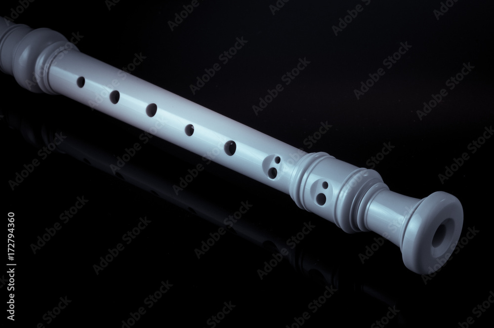 classical musical instrument is the block flute on black background ...
