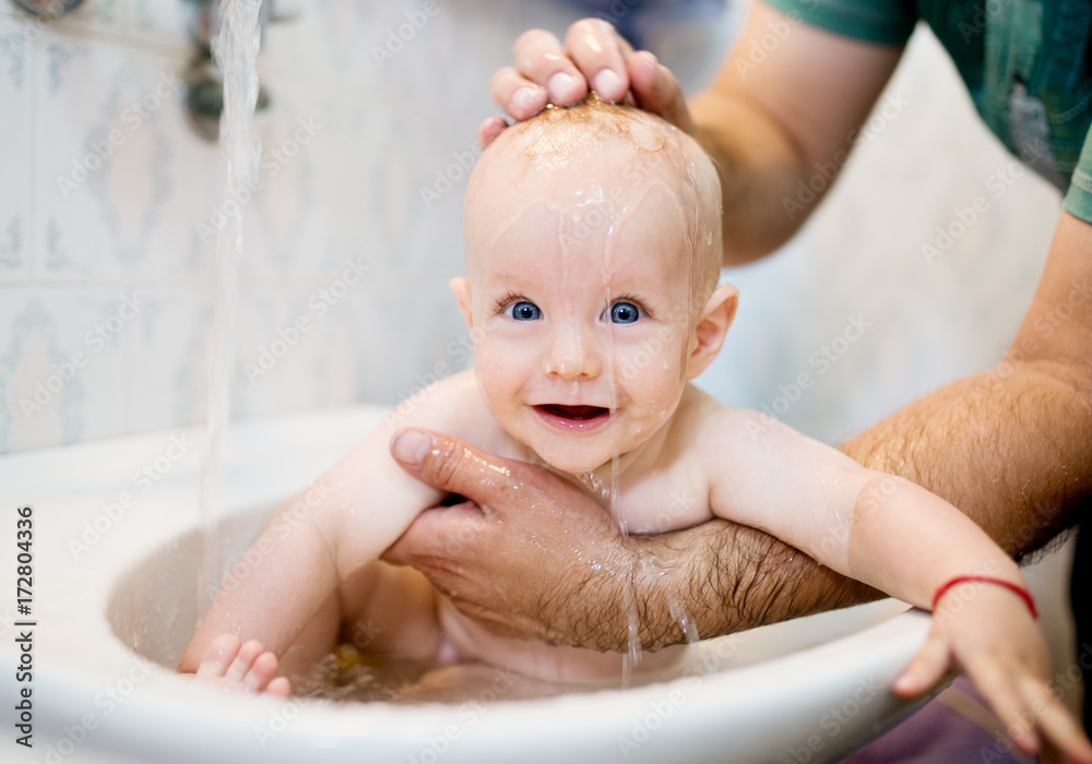 Happy laughing baby taking a bath. Little child in a bathtub. Smiling ...