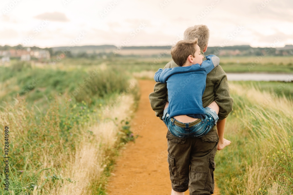 Dad carries his tired child home piggyback style Stock Photo | Adobe Stock