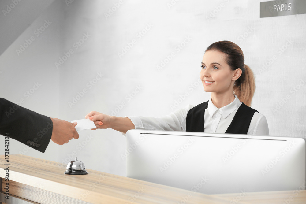 Female receptionist giving key card from hotel room to client Stock ...