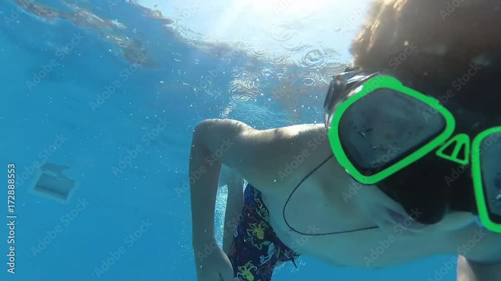 Boy dive in swimming pool and looking at the camera, underwater shoot ...