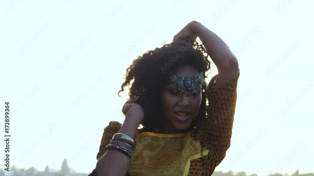 Portrait of young afro-american gypsy woman in colorful yellow ...