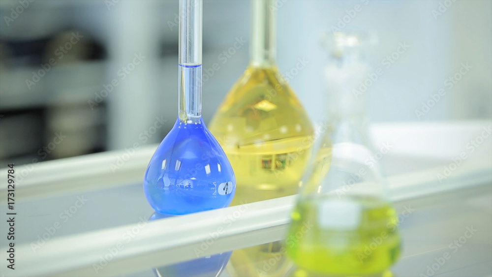 Chemical flasks with green and blue liquid on white background. Test ...