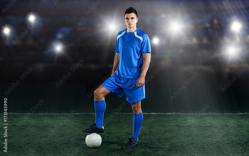 soccer player in front of big modern stadium with flares and lights ...