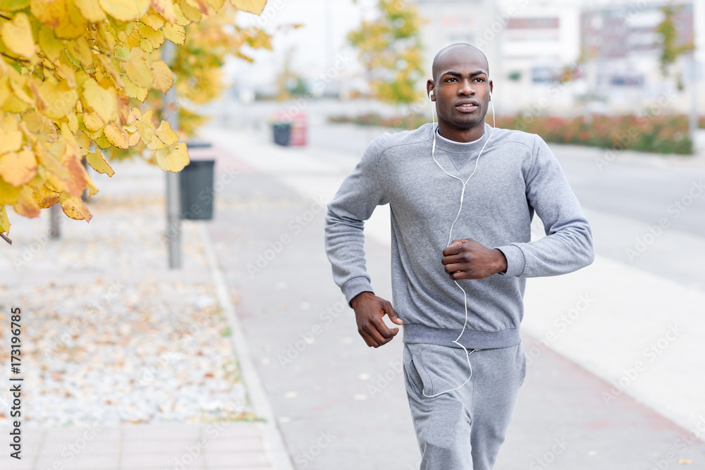 Attractive black man running in urban background Stock Photo | Adobe Stock
