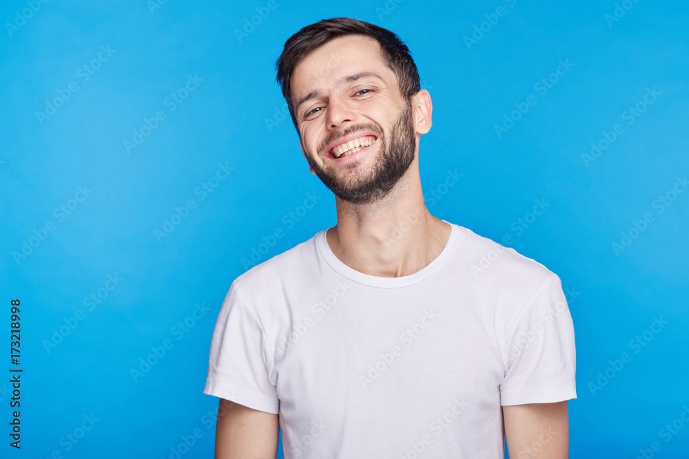 Handsome unshaven young European male laughing out loud at funny joke ...