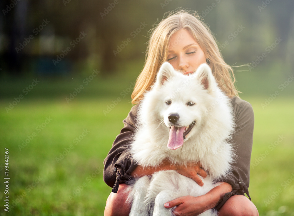 Pretty happy girl playing with her dog at the park, samoyed Stock Photo ...