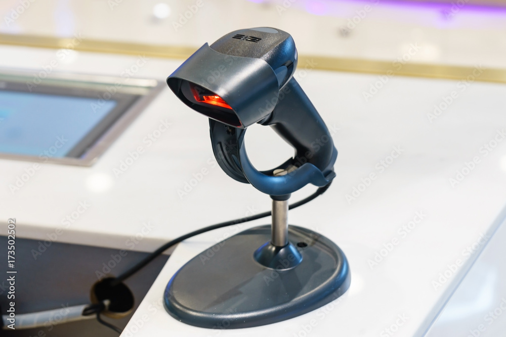 Cash desk with computer screen and barcode scanner on white table in ...