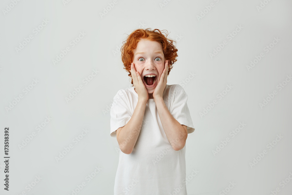 Excited redhead boy with freckles holding face with hands, with happy ...