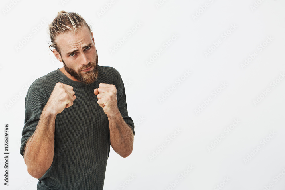 Strong attractive guy with stylish hairstyle and beard holding hands in ...